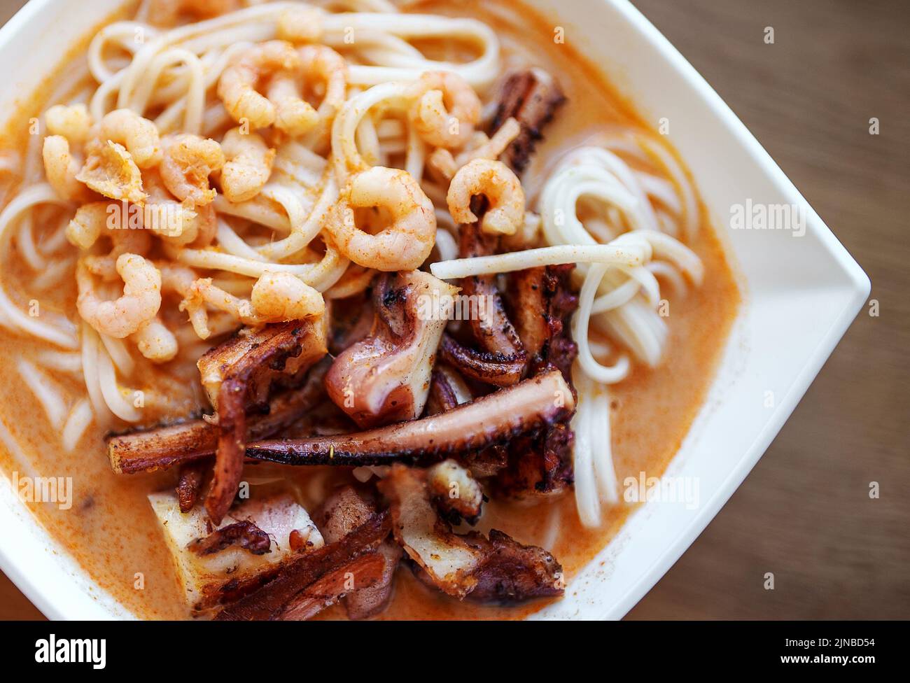Spicy Asian soup with noodles, octopus and shrimp Stock Photo - Alamy
