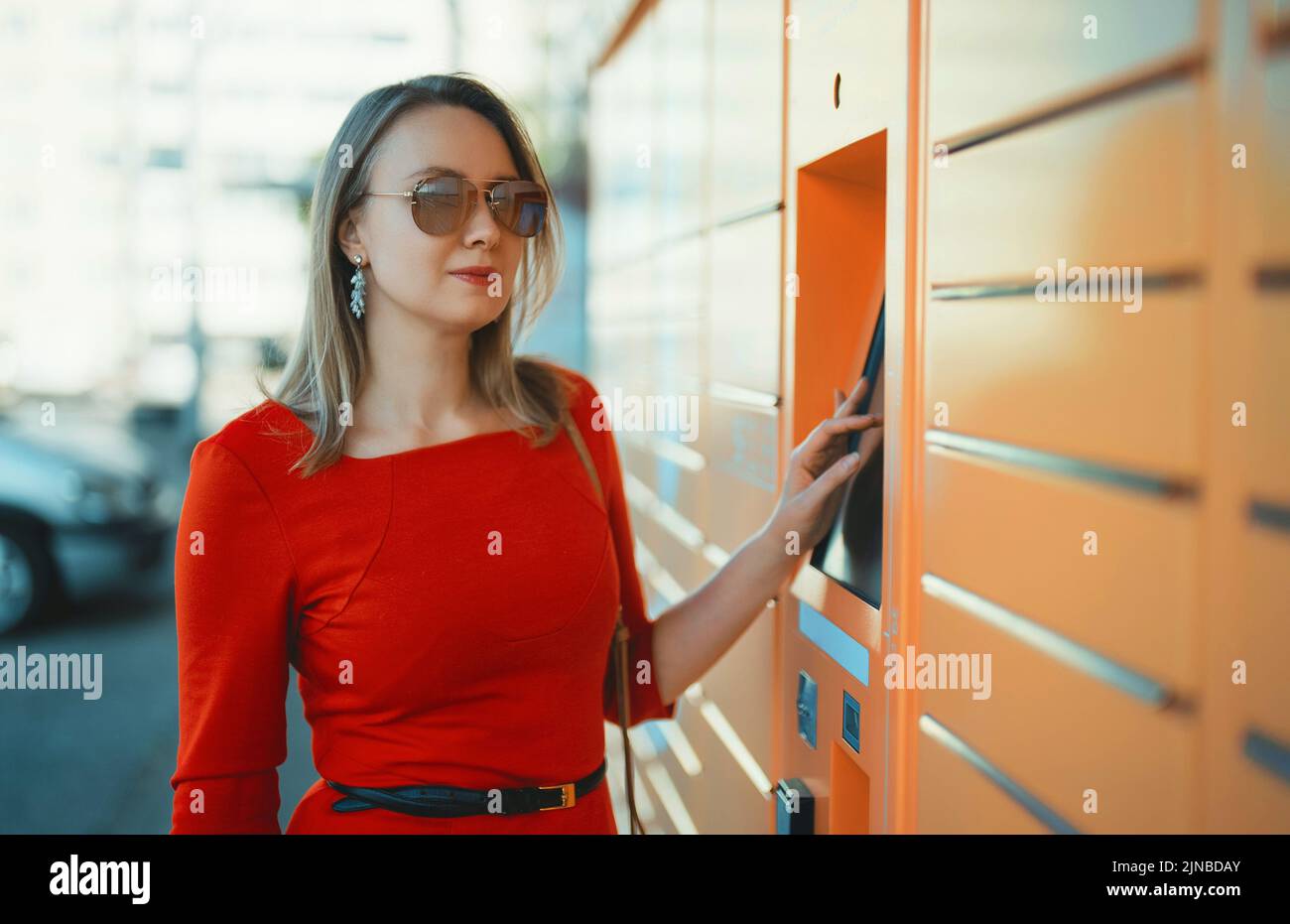 Woman picks up mail from automated self-service post terminal machine ...