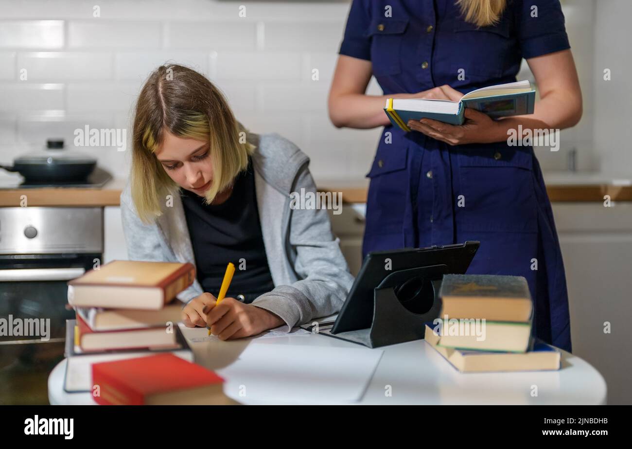 Teenage girl and her mother doing schoolwork at home Stock Photo - Alamy