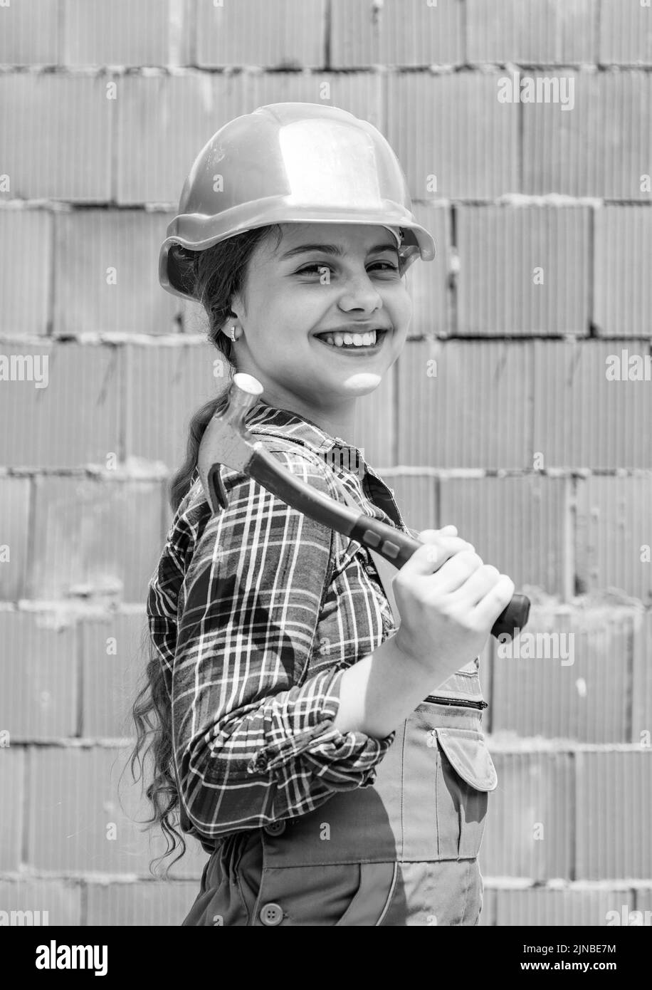 Repair concept. kid wear helmet on construction site. teen girl builder ...