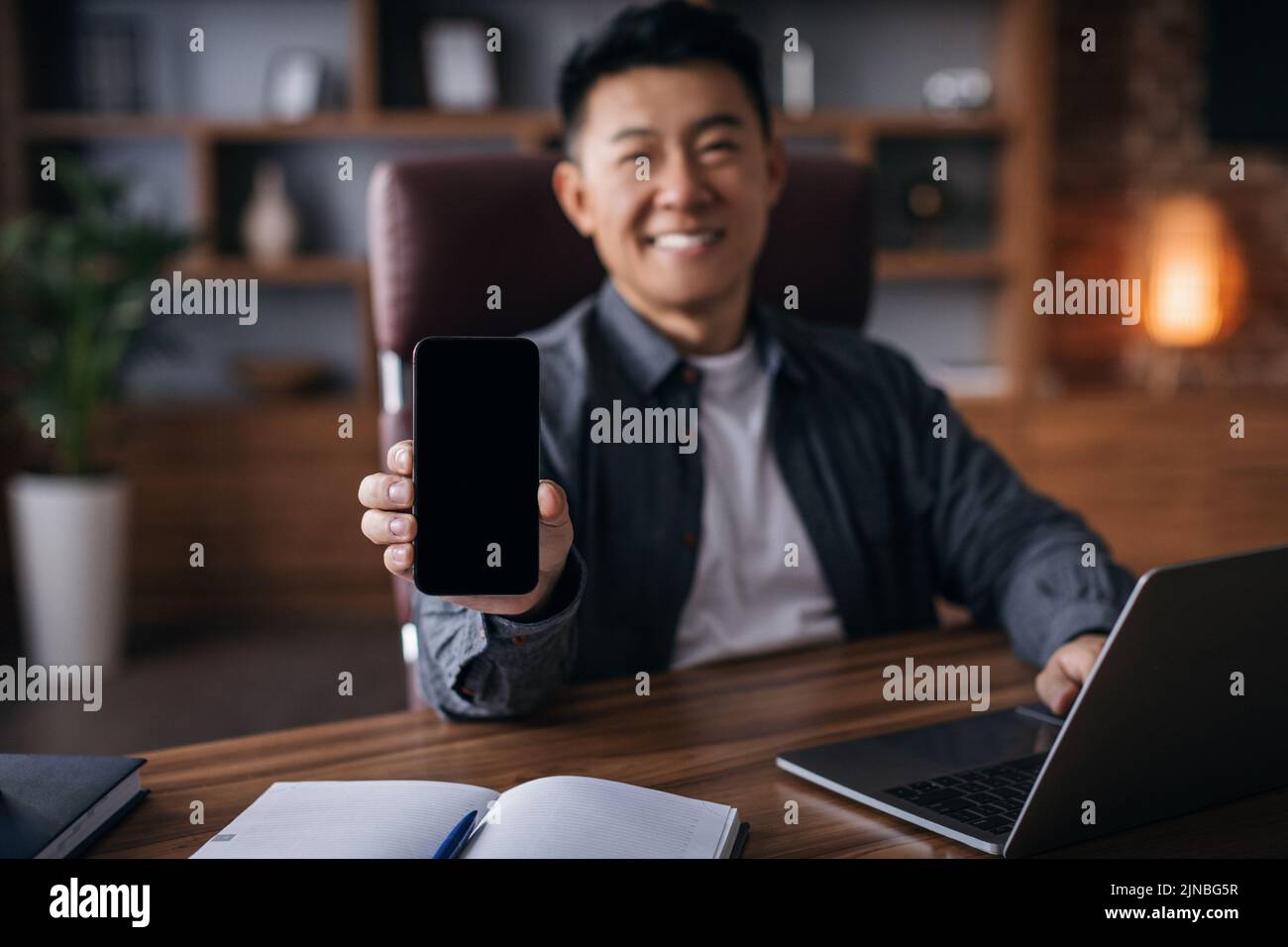 Cheerful adult asian man manager work at table with laptop, show ...