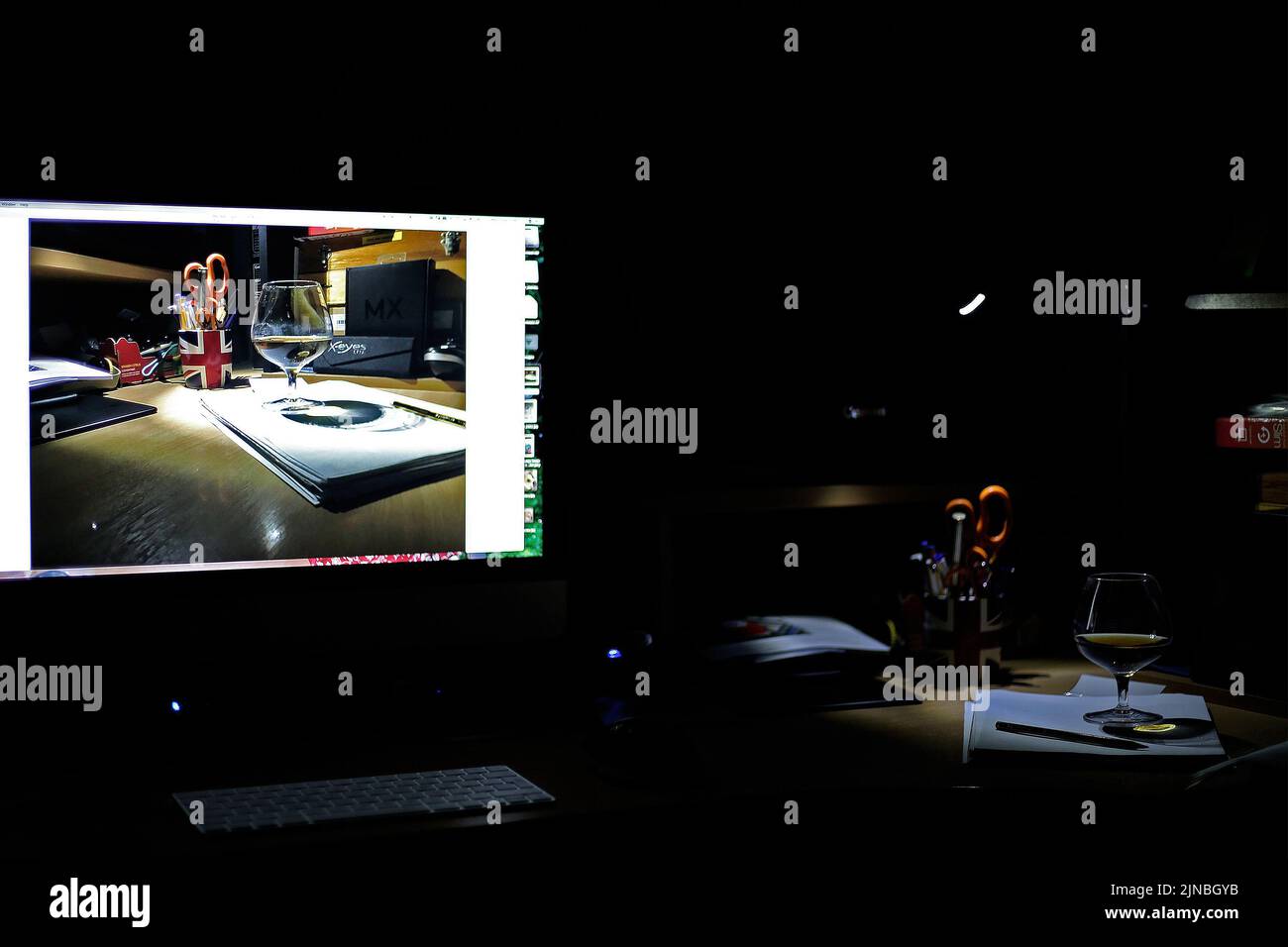 An IT desk pictured in low lighting with shadows and a little bright ...