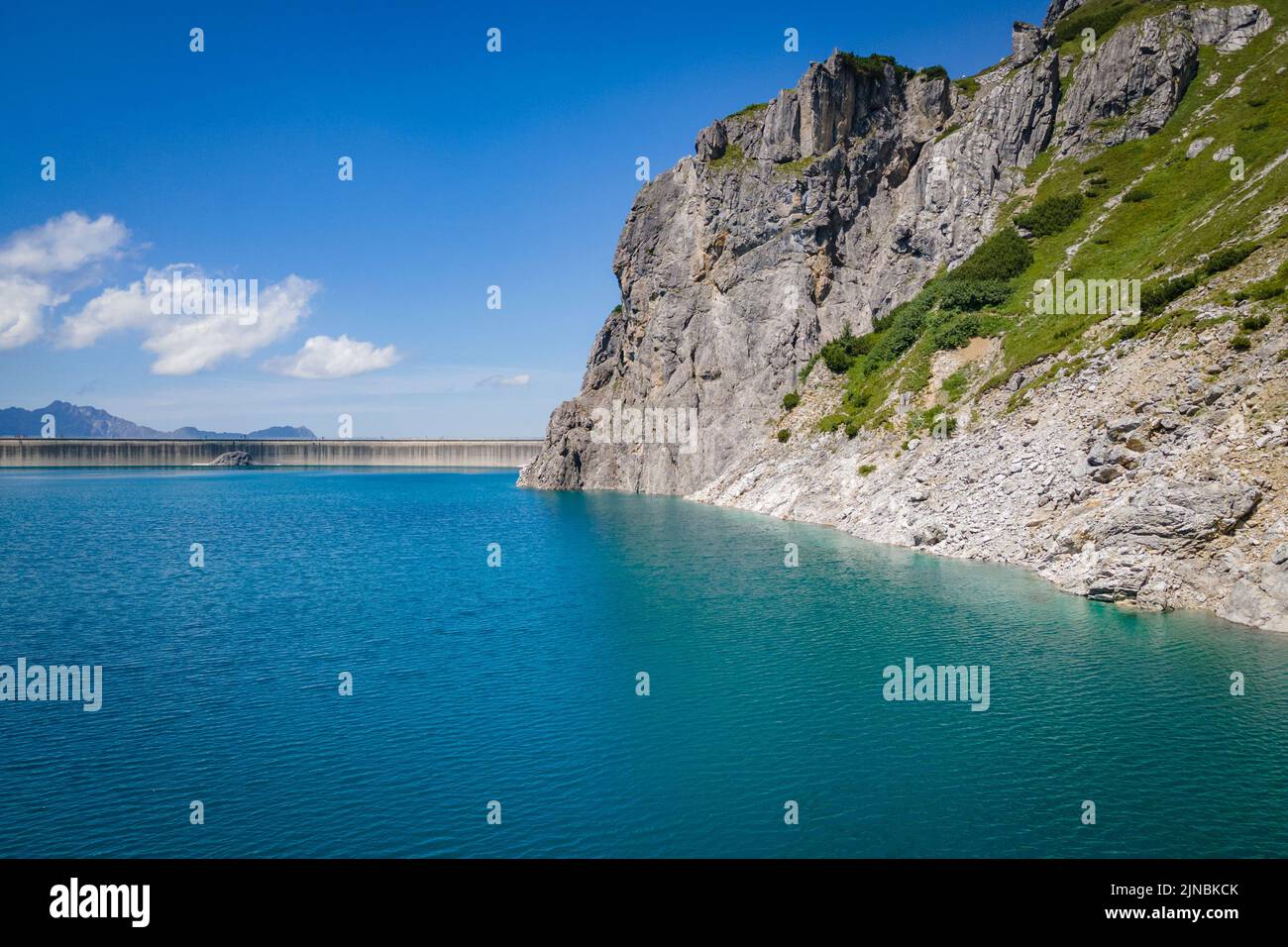 Aerial shot of the Luenersee with dam wall and rocks in Vorarlberg ...