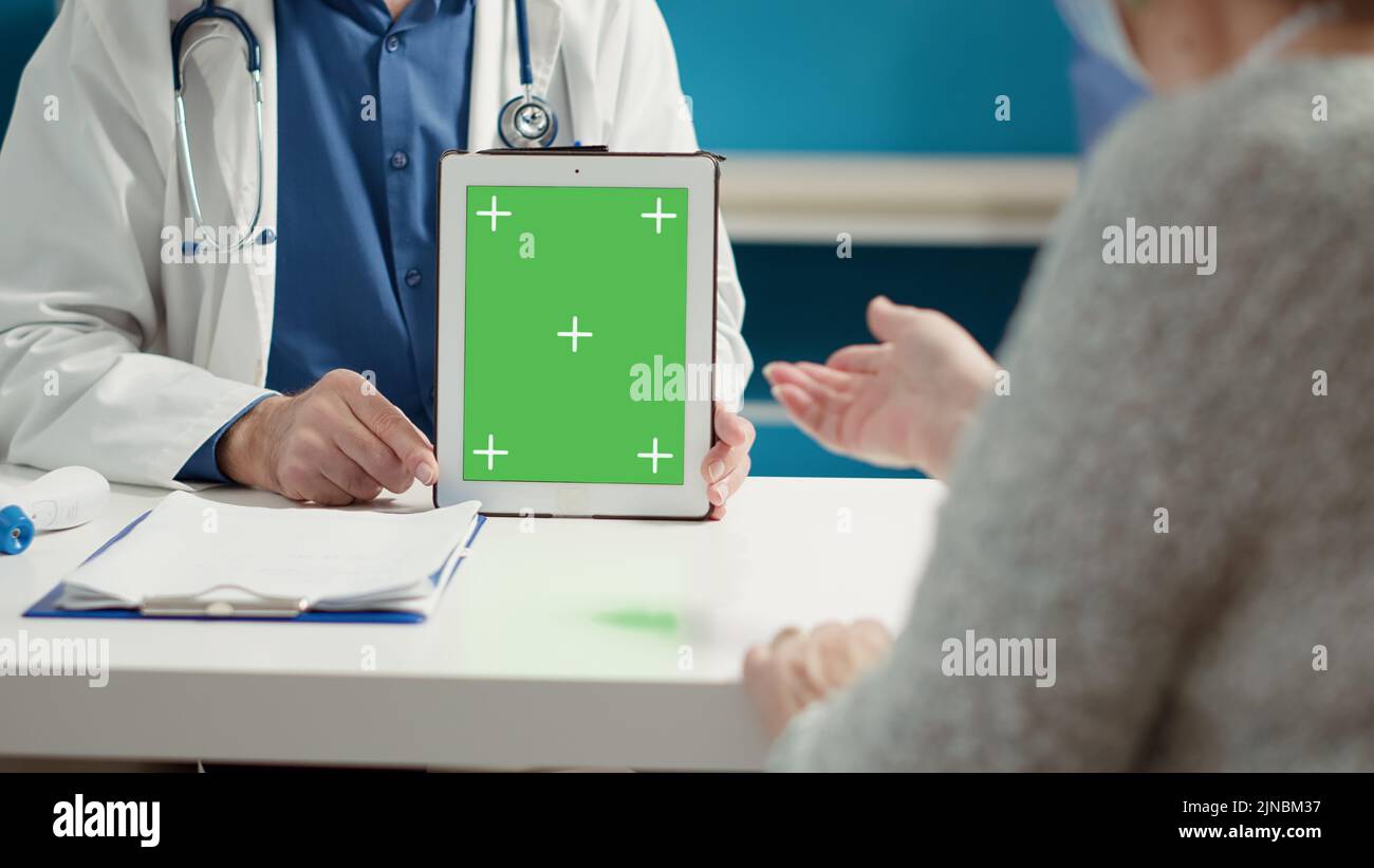 Medical specialist holding digital tablet with greenscreen at ...