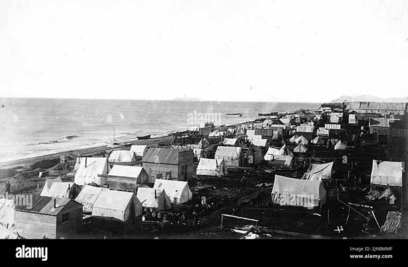 Tents and wooden structures on beach at Nome, looking west, with Sledge ...