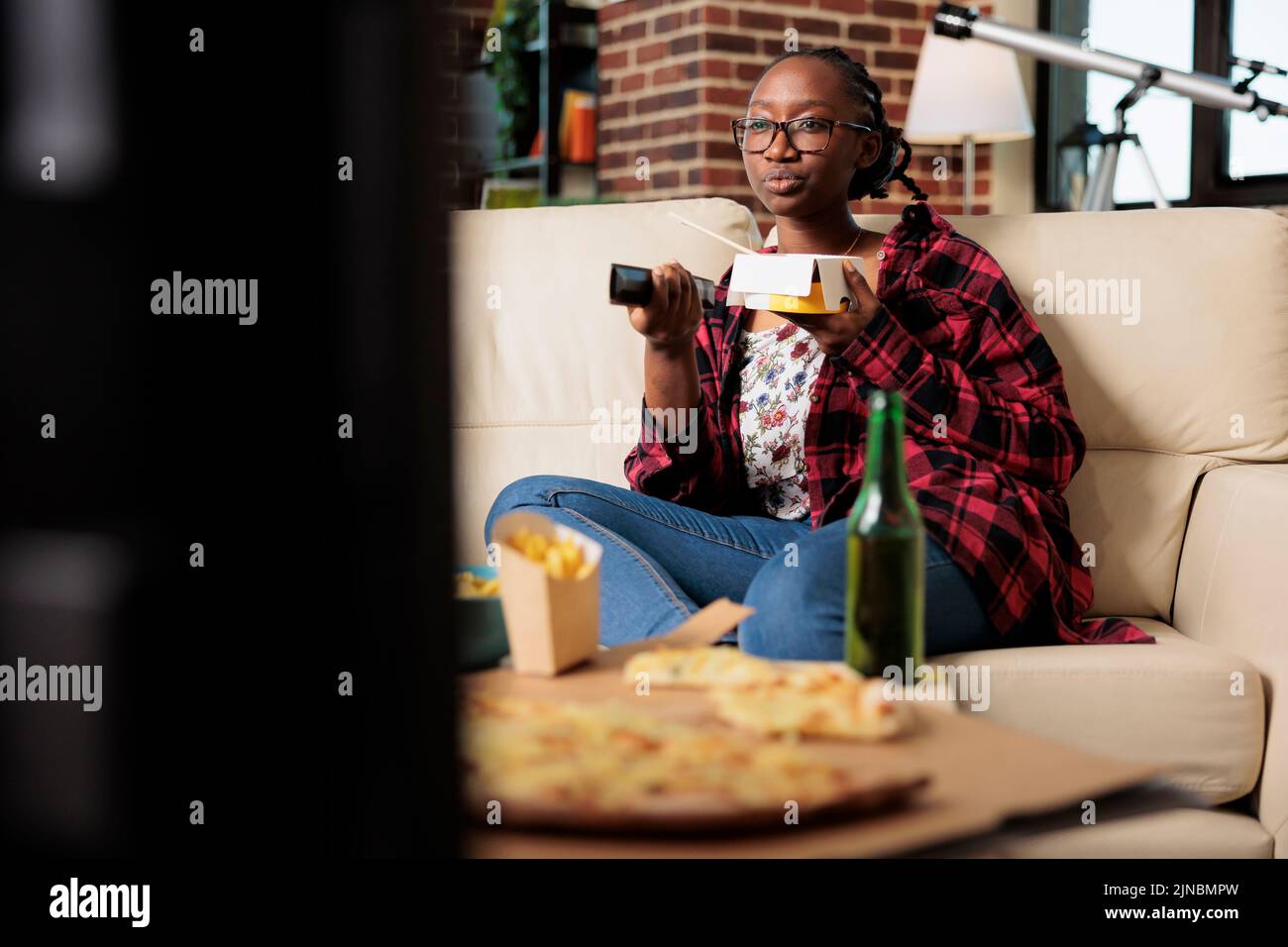 Happy person switching channel program on television to eat noodles ...