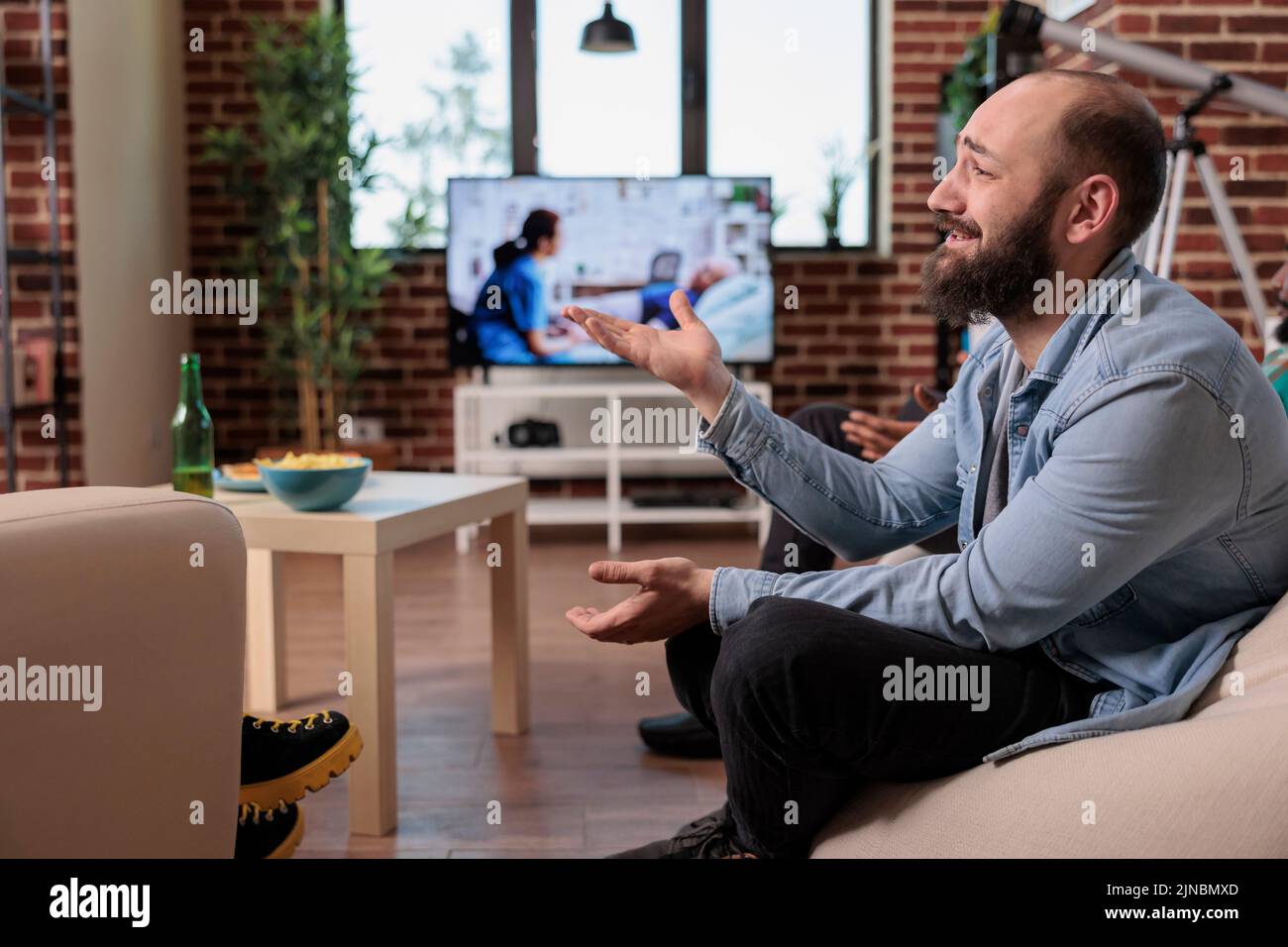 Multiethnic group of friends having fun with television film, watching ...