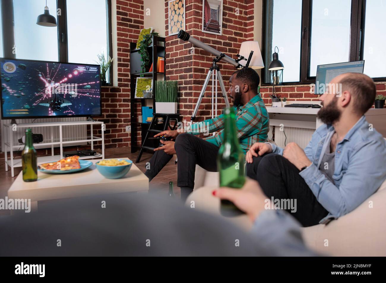 Young adult using joystick and console to play video games at home ...