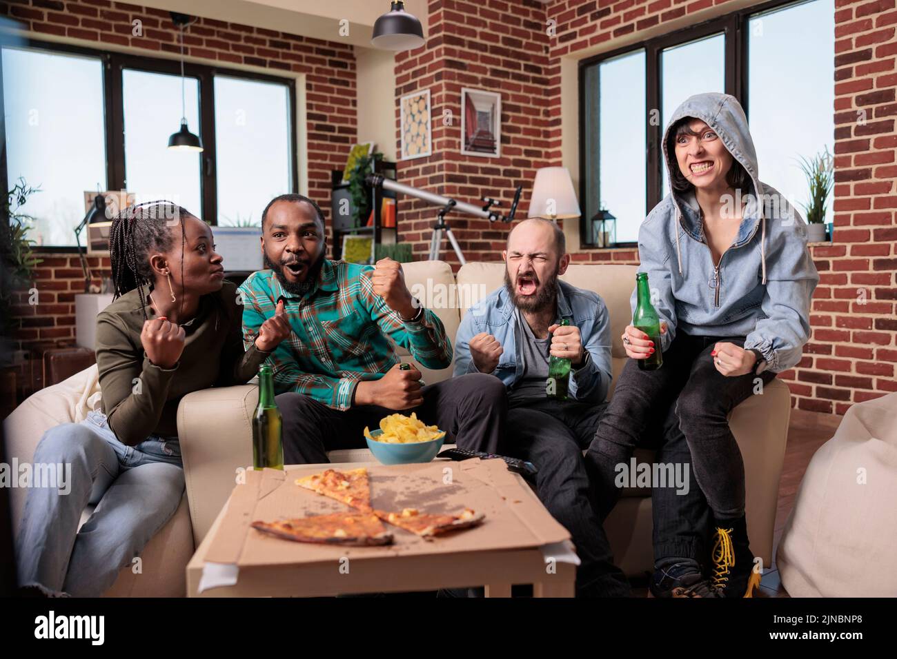 Multiethnic group of friends celebrating football game win, enjoying ...