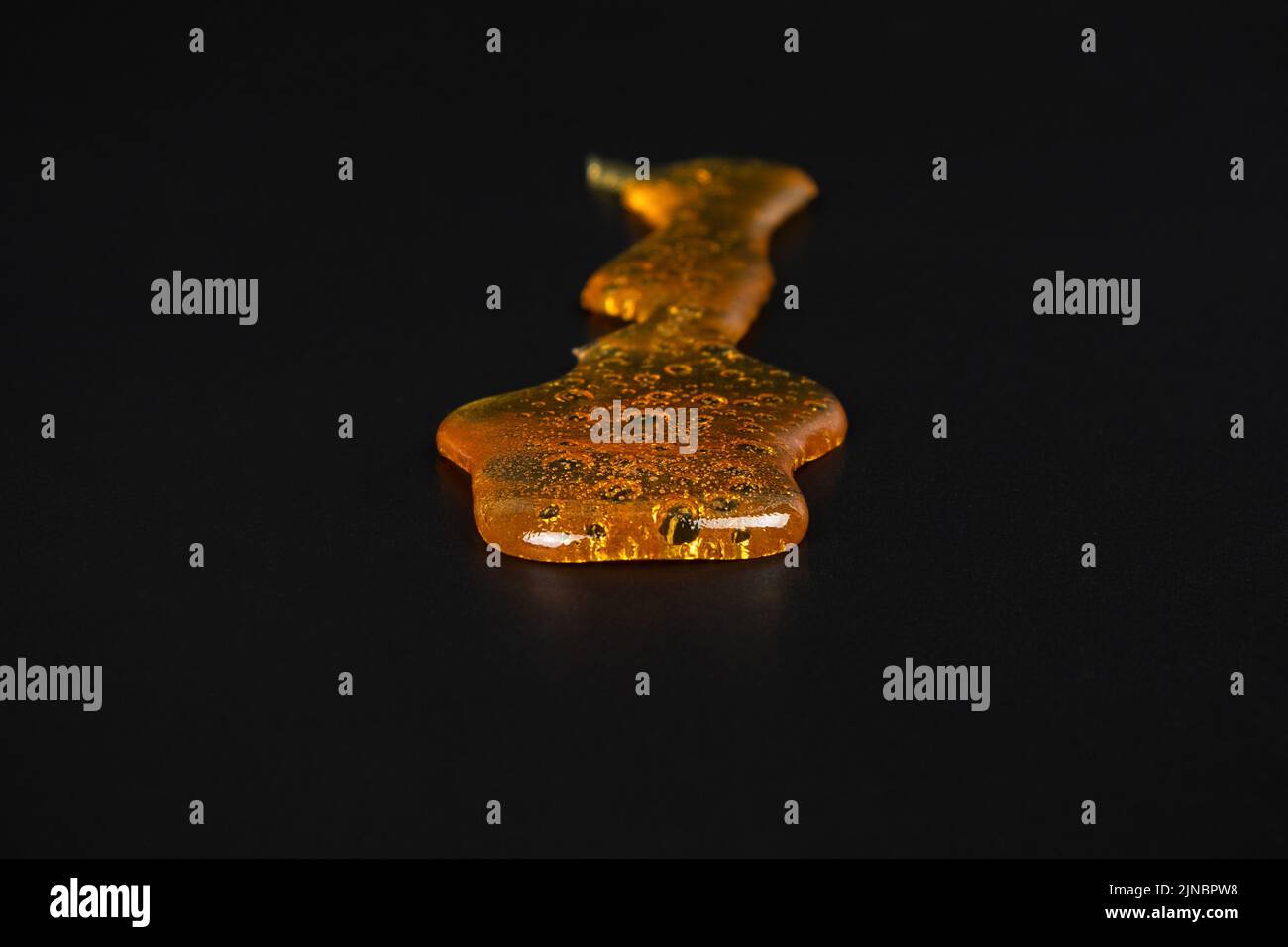 golden cannabis wax resin smear on dark background Stock Photo - Alamy