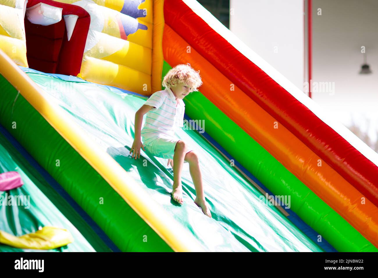 Child jumping on colorful playground trampoline. Kids jump in ...
