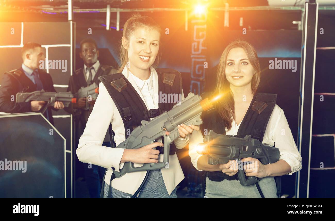 Portrait of two women in business suits playing laser tag with c Stock ...