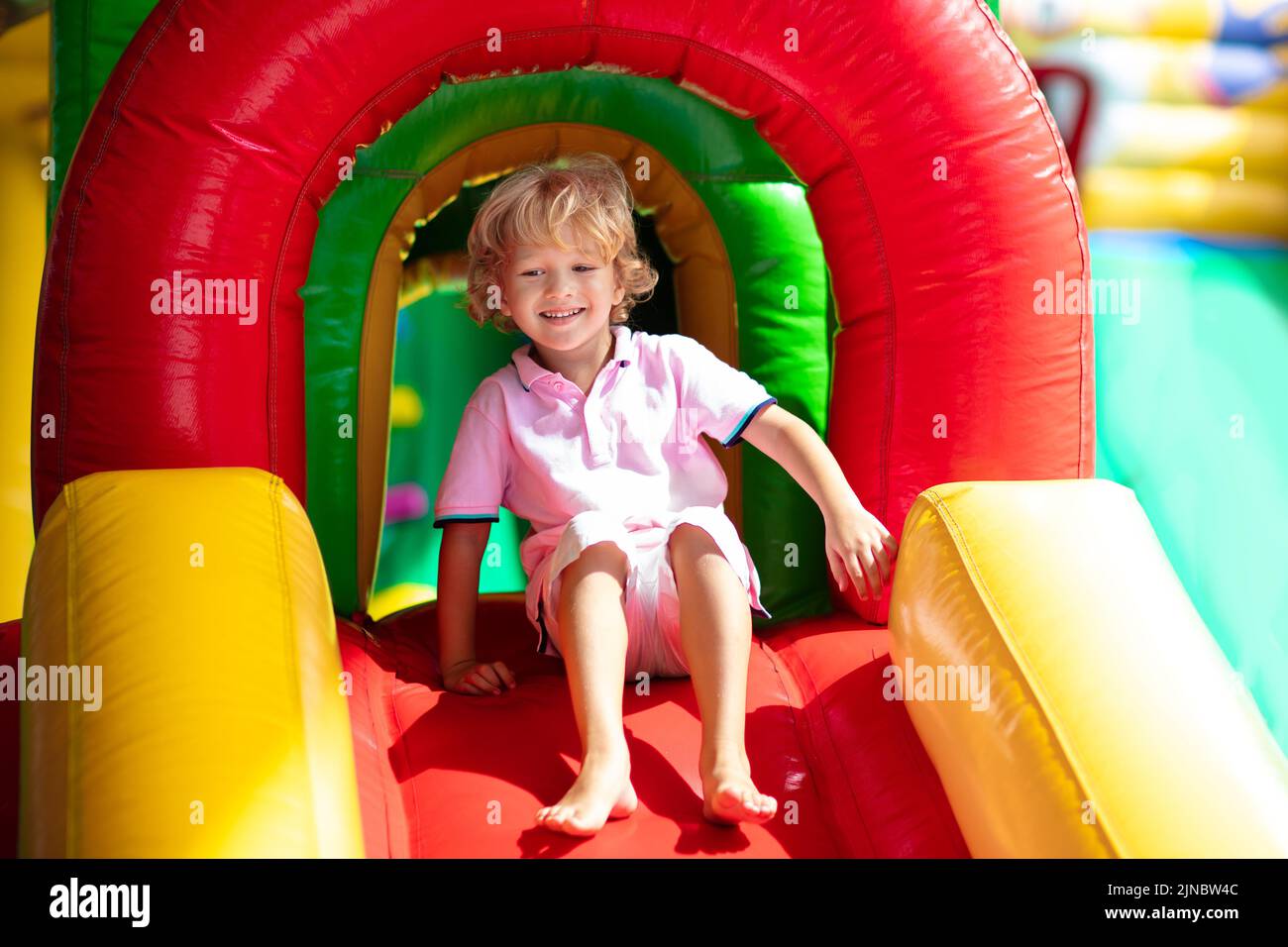 Child jumping on colorful playground trampoline. Kids jump in ...