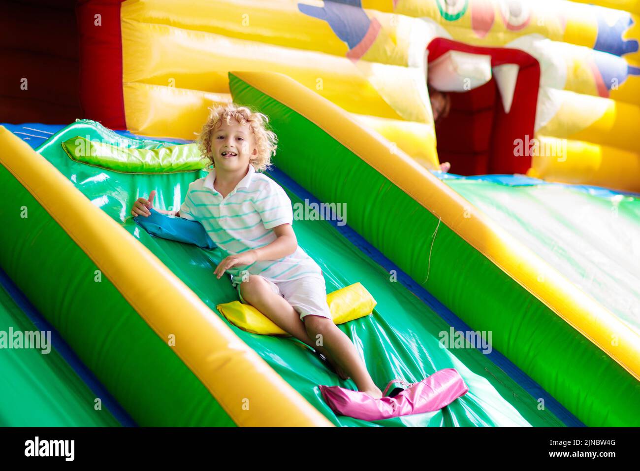 Child jumping on colorful playground trampoline. Kids jump in ...