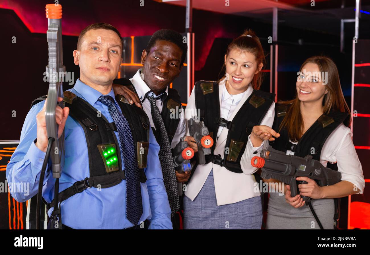 Group portrait of happy colleagues having fun at laser tag room Stock ...
