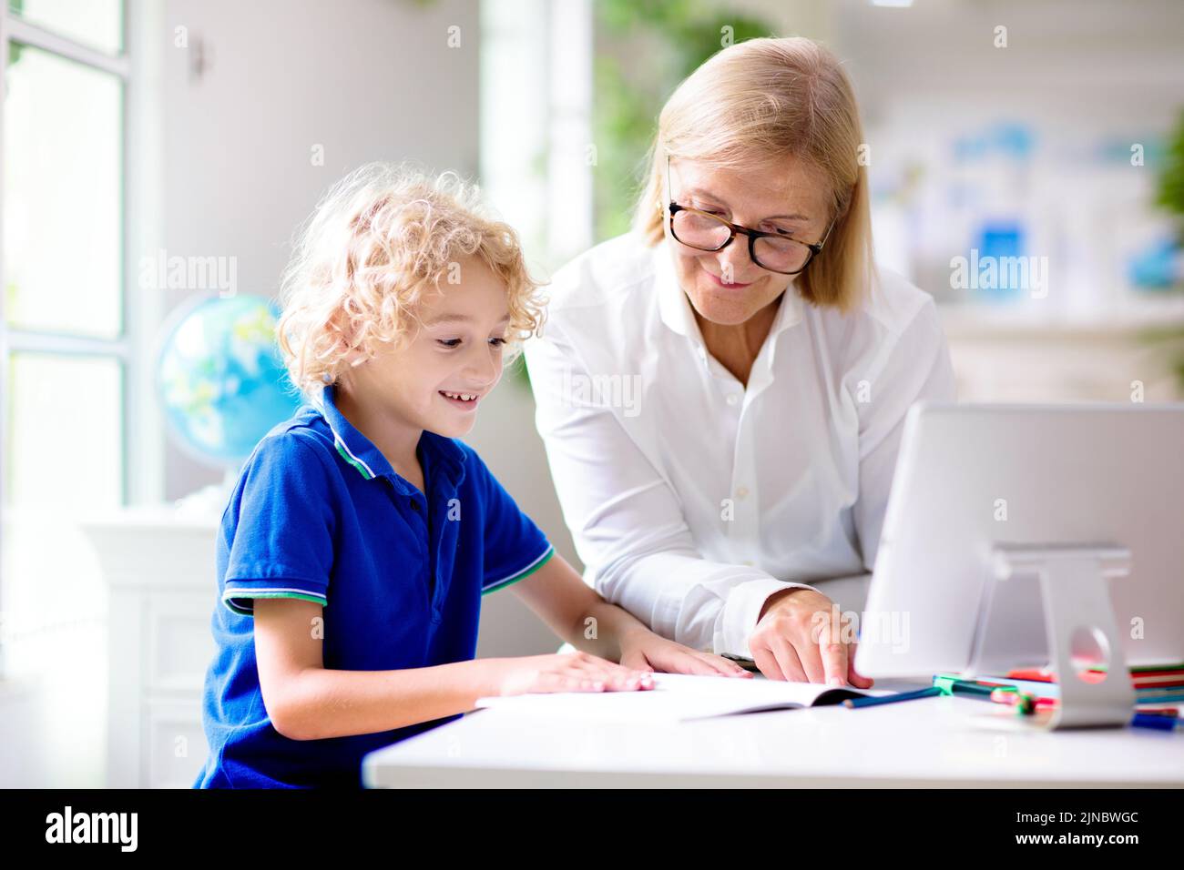 Online remote learning. School kids with computer having video ...