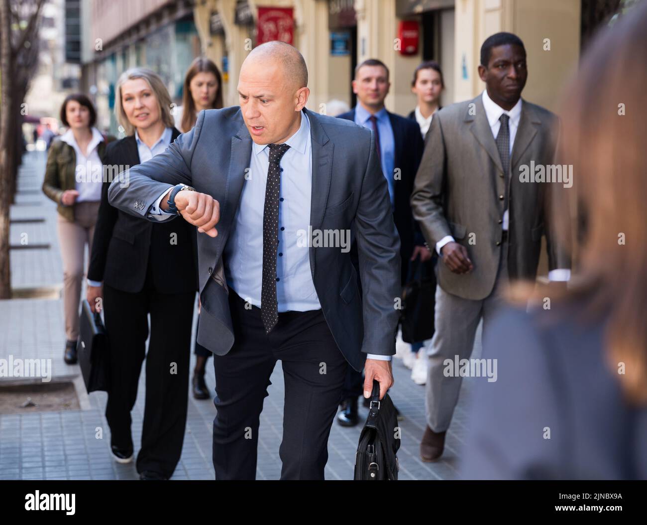 Stressed businessman checking time and running Stock Photo - Alamy