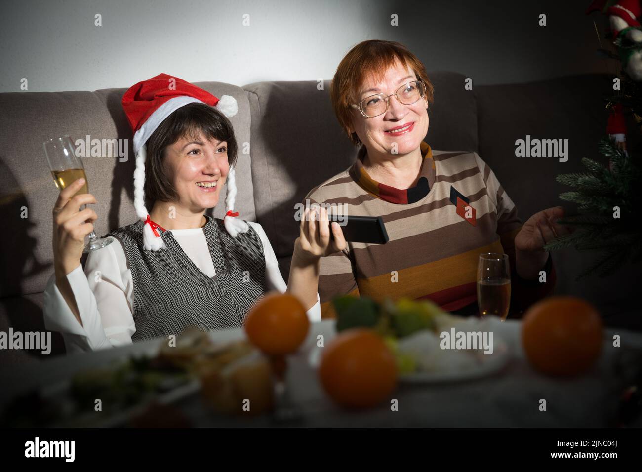 Woman santa hat watching television hi-res stock photography and images ...