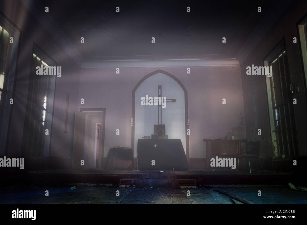 The interior of an abandoned room for worship with lights hitting from ...