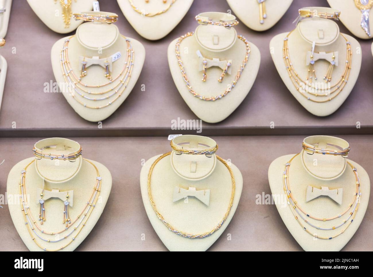 Gold jewelry at showcase of jewelry shop. Gold items in shop windows ...