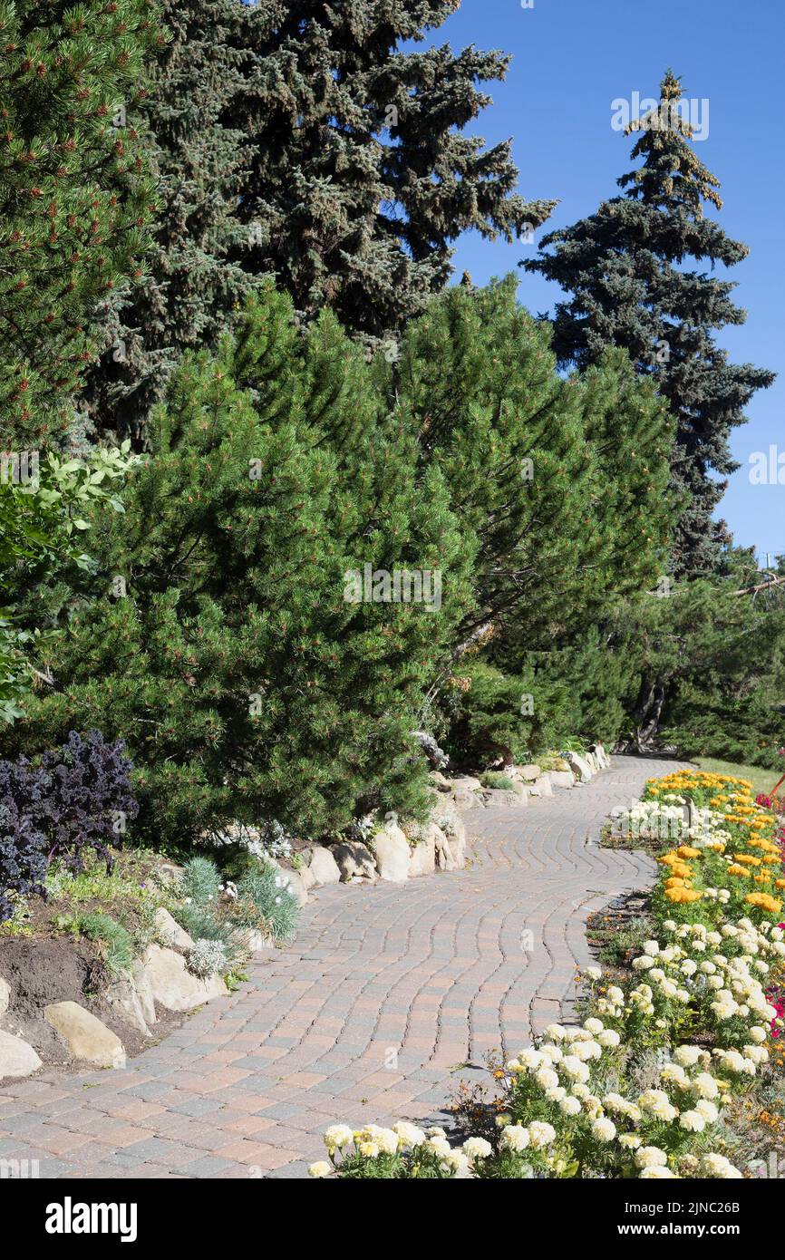 Walking path through green space with flower garden in a neighbourhood ...