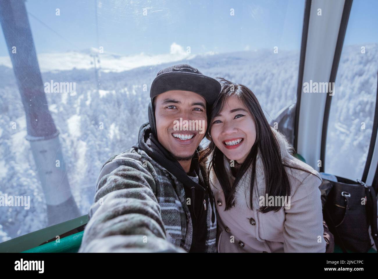 couple riding a cable car in the beautiful snowy mountain in turkey ...