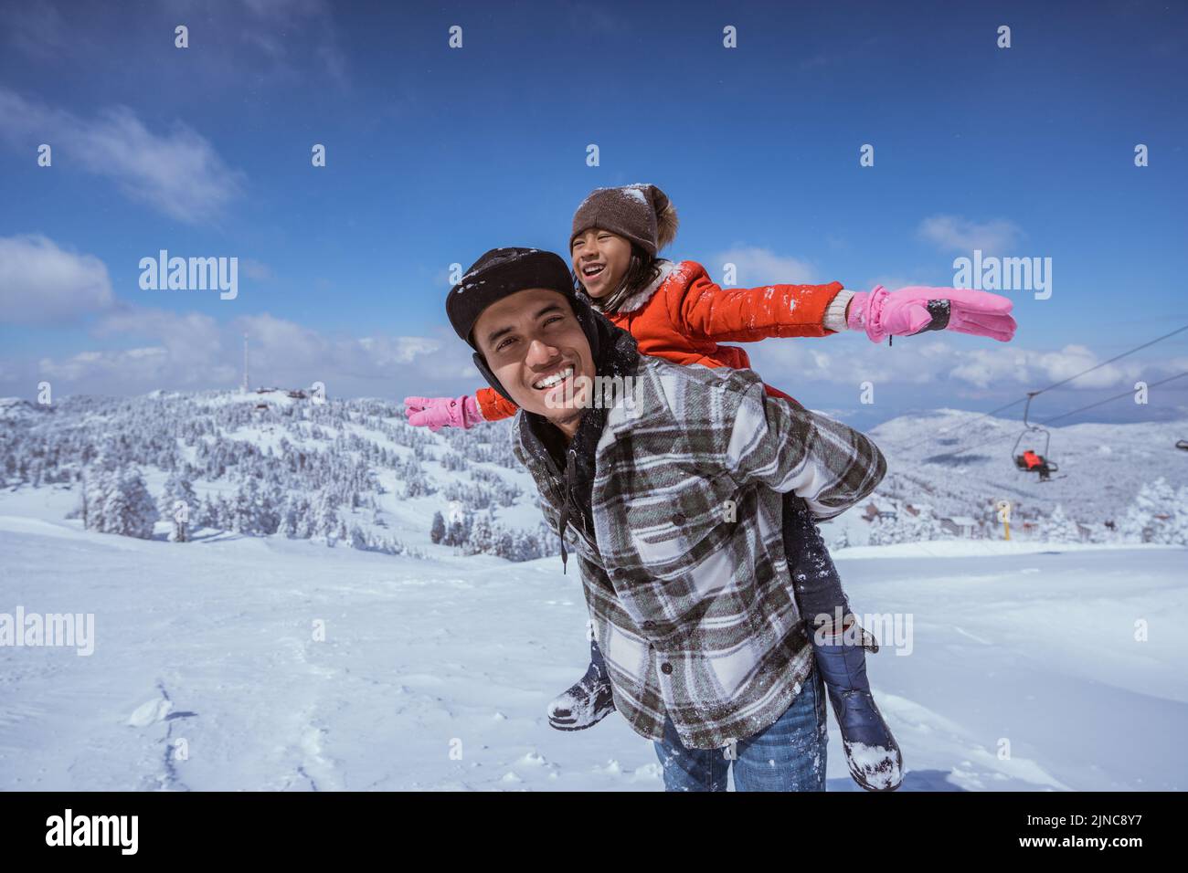 father piggyback ride with daughter while playing outside in snow Stock ...
