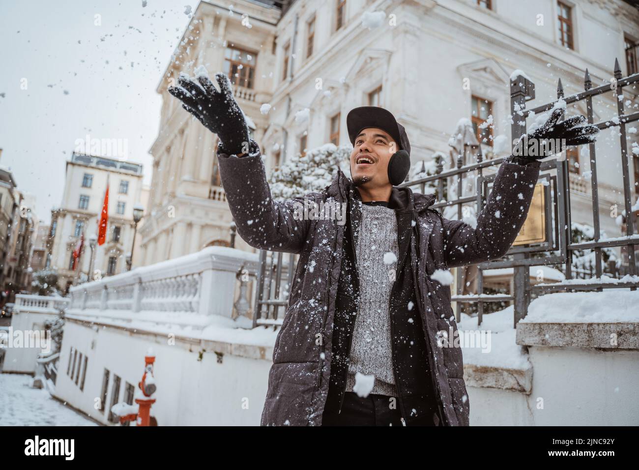 man touching snow for the first time during visiting european country ...