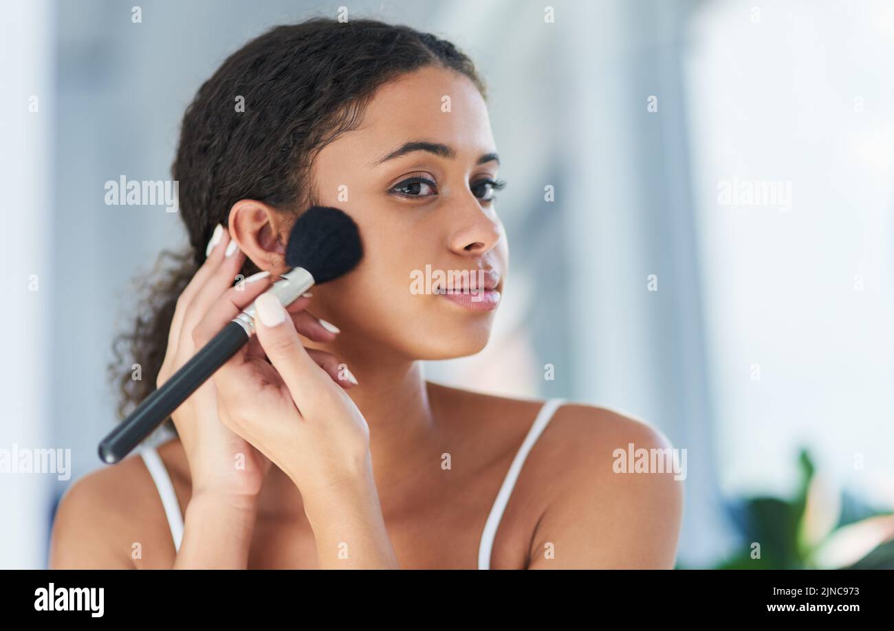 Add a dash of magic to each day. a young woman applying makeup to her ...