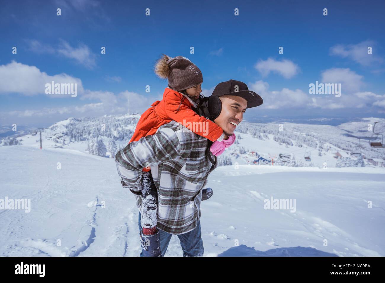 father piggyback ride with daughter while playing outside in snow Stock ...
