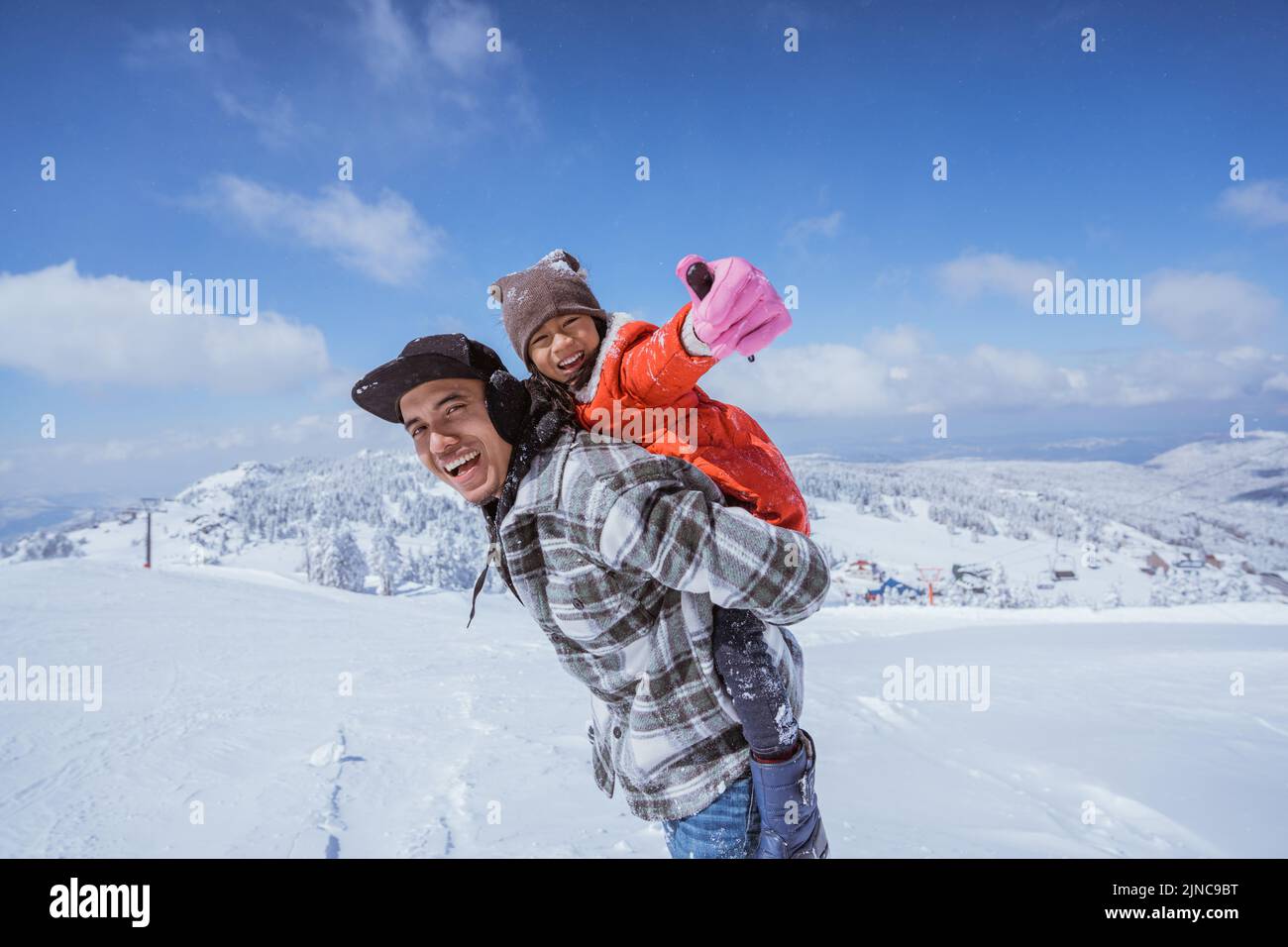 father piggyback ride with daughter while playing outside in snow Stock ...