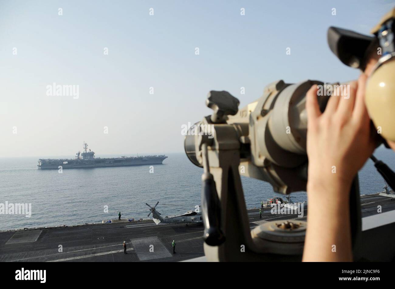 The aircraft carrier USS Carl Vinson (CVN 70), background, relieves the ...
