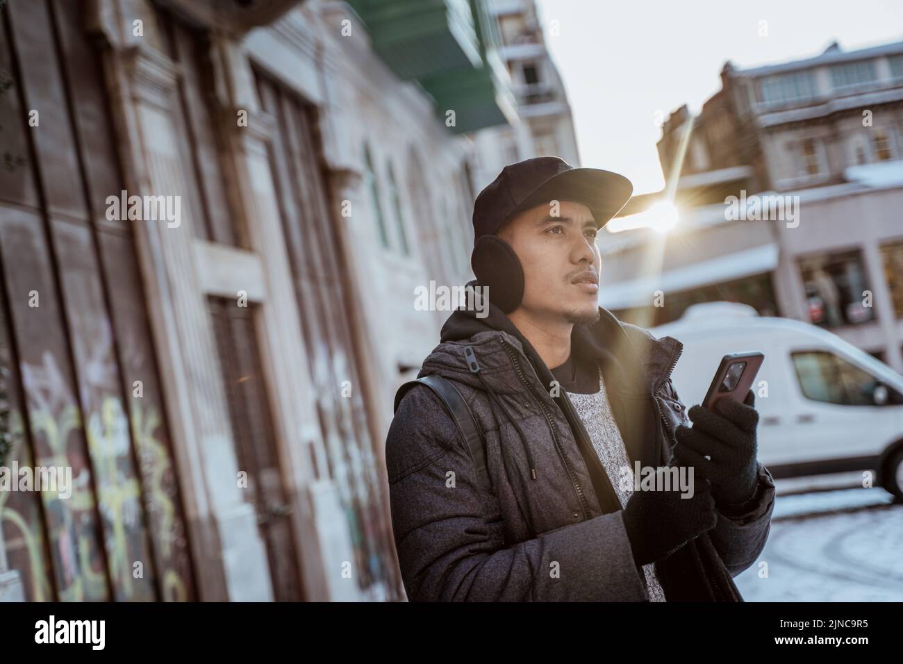 man wearing jacket and holding his phone Stock Photo - Alamy