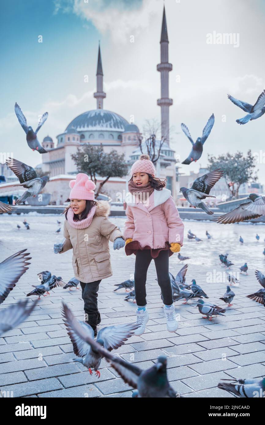 girl playing and chasing pigeons in city square Stock Photo - Alamy