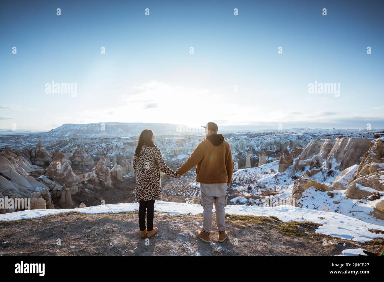 couple holding hand and looking at the beautiful valley of cappadocia ...