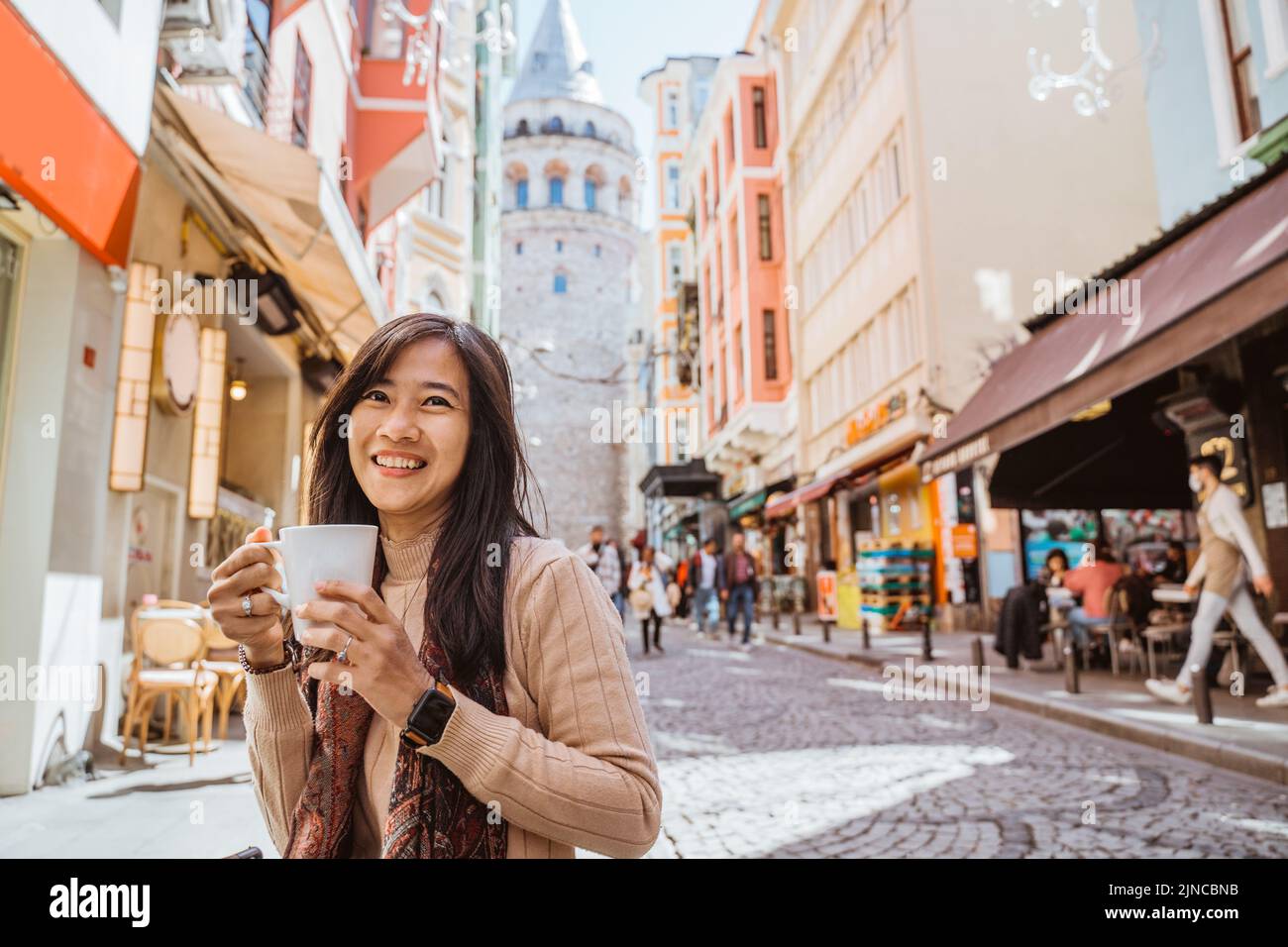 woman enjoy drinking a cup of coffee while sitting in historical city ...