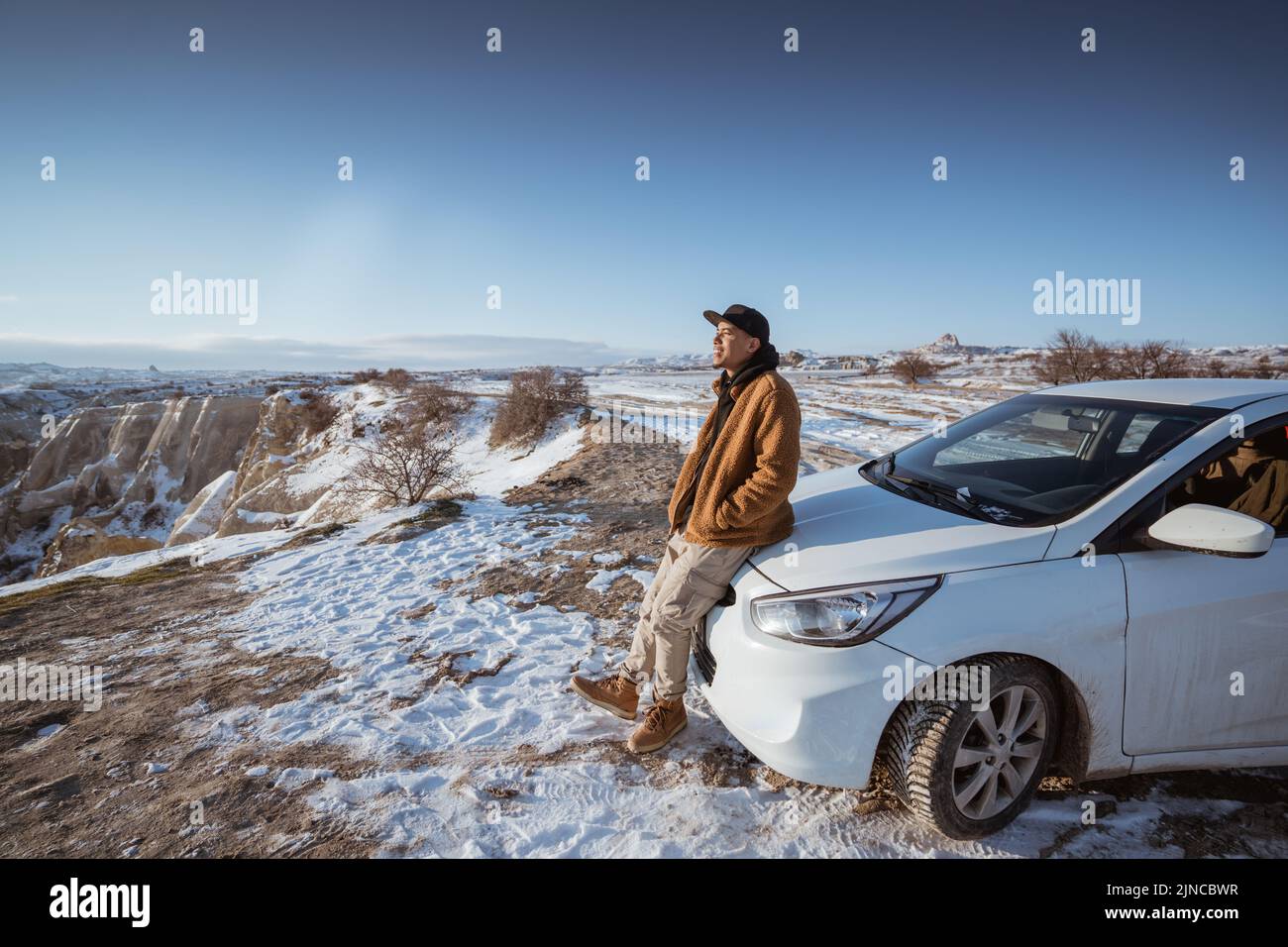 man enjoying the view of cappadocia in winter sitting at the front of ...