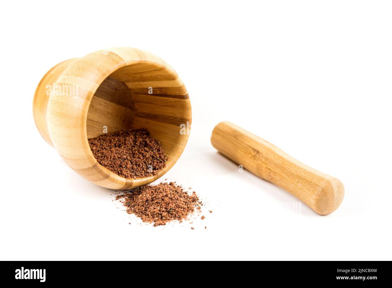 Ground dried sumac berry powder tipped out of a wooden mortar and ...