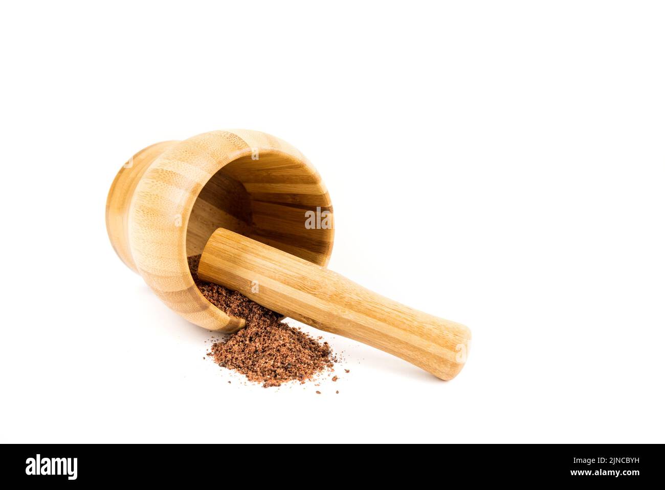 Ground dried sumac berry powder tipping out of a wooden mortar and ...