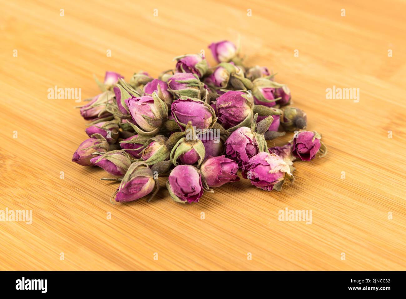 Dehydrated pink rose buds on a wooden cutting board Stock Photo - Alamy