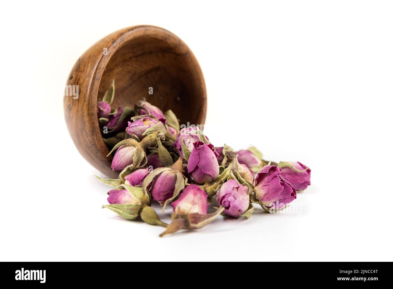 Dehydrated pink rose buds spilling from a small wooden bowl Stock Photo ...