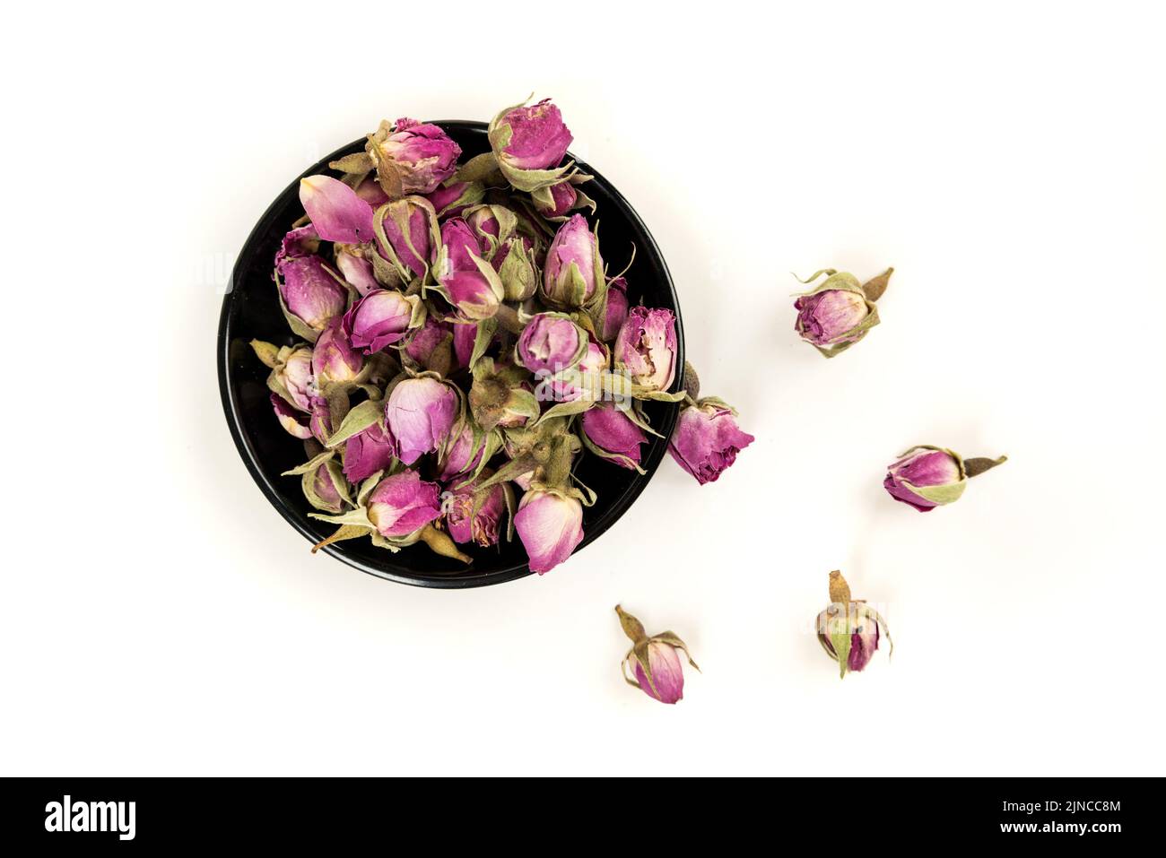 Dehydrated pink rose buds in a black bowl top down view Stock Photo - Alamy