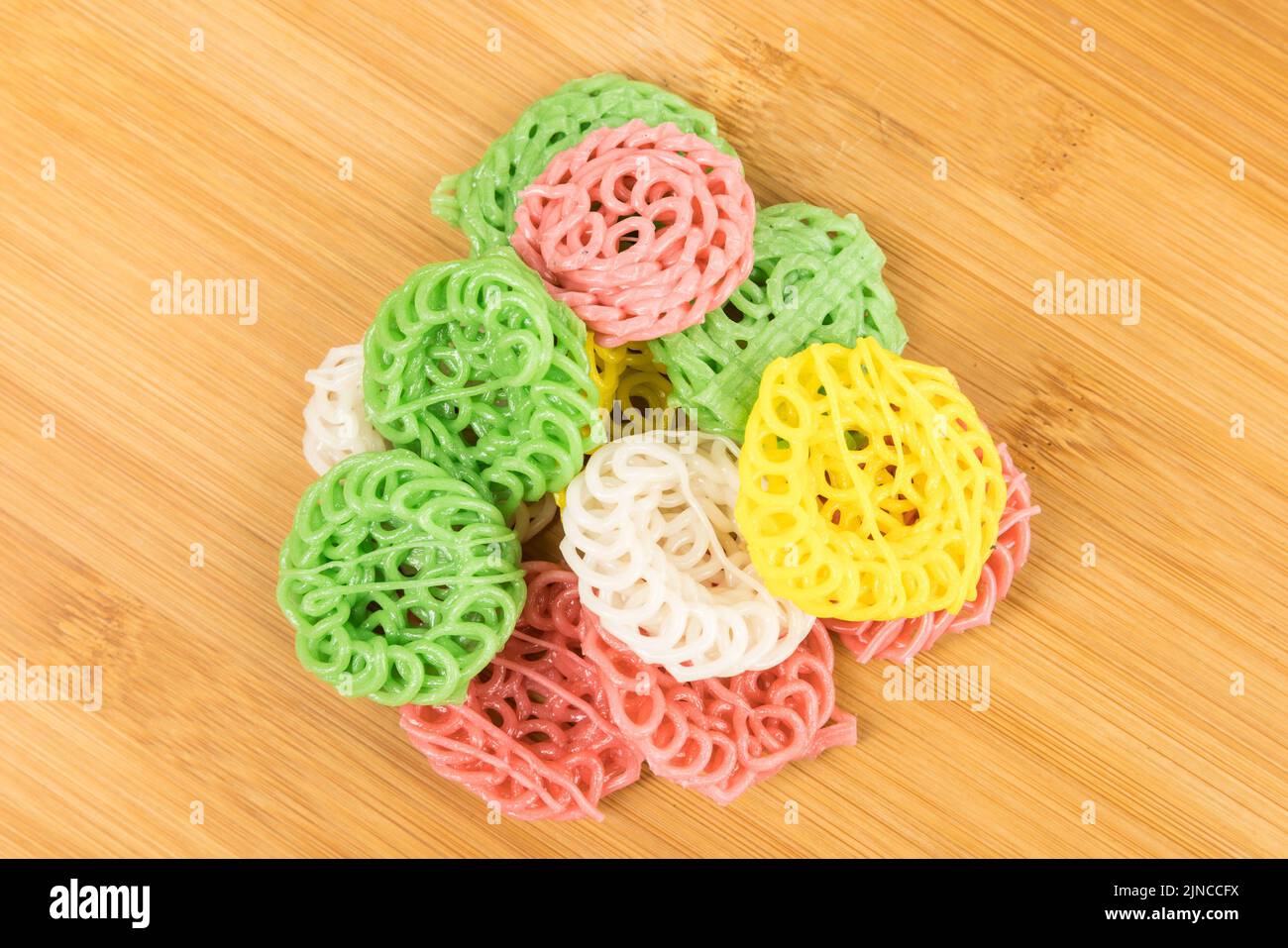 Raw multicolored tapioca crackers on a cutting board top down isolated ...