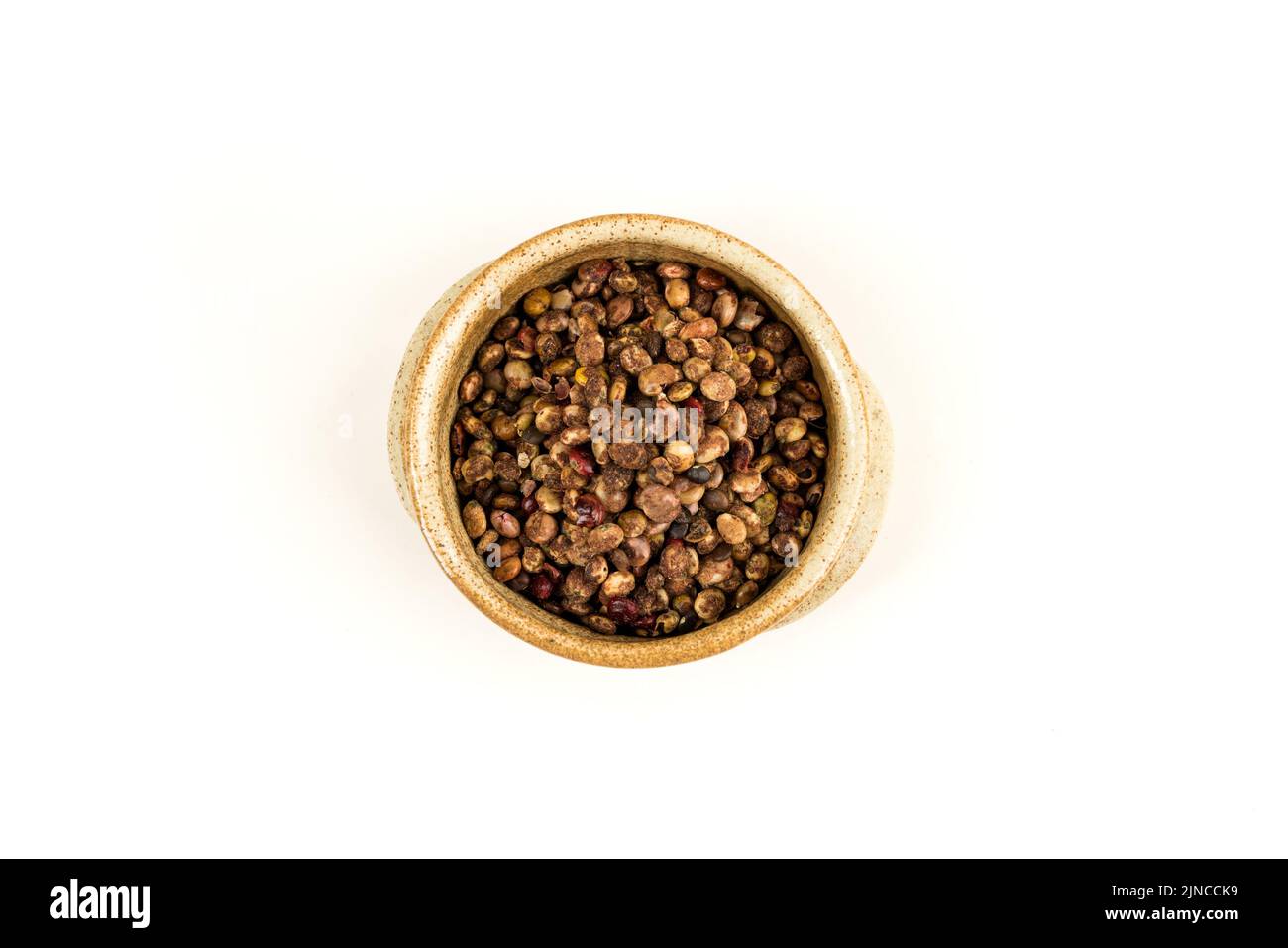 Whole dried sumac berries in a small earthenware bowl over white top ...
