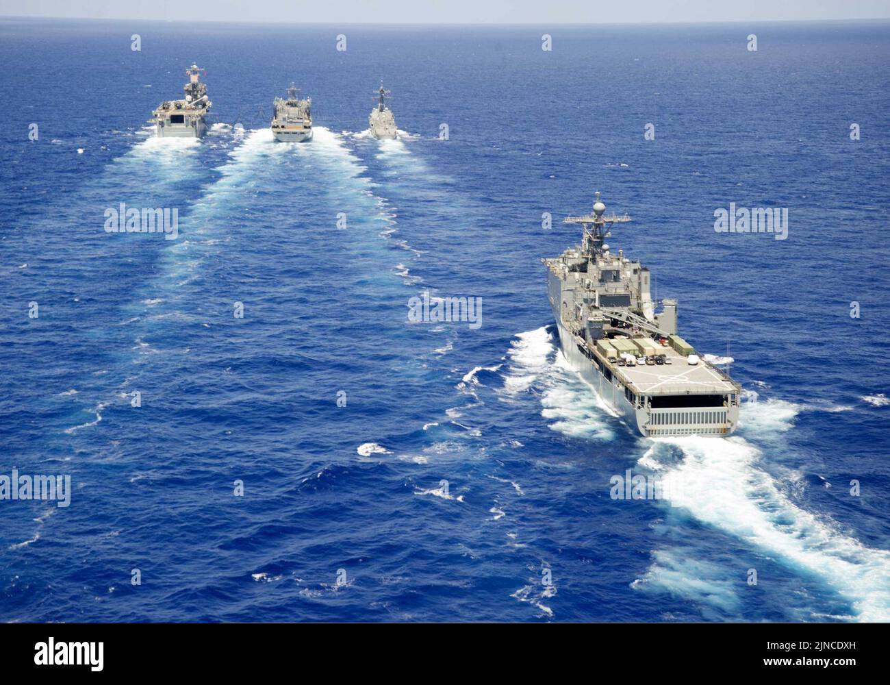 The amphibious dock landing ship USS Rushmore (LSD 47), foreground ...