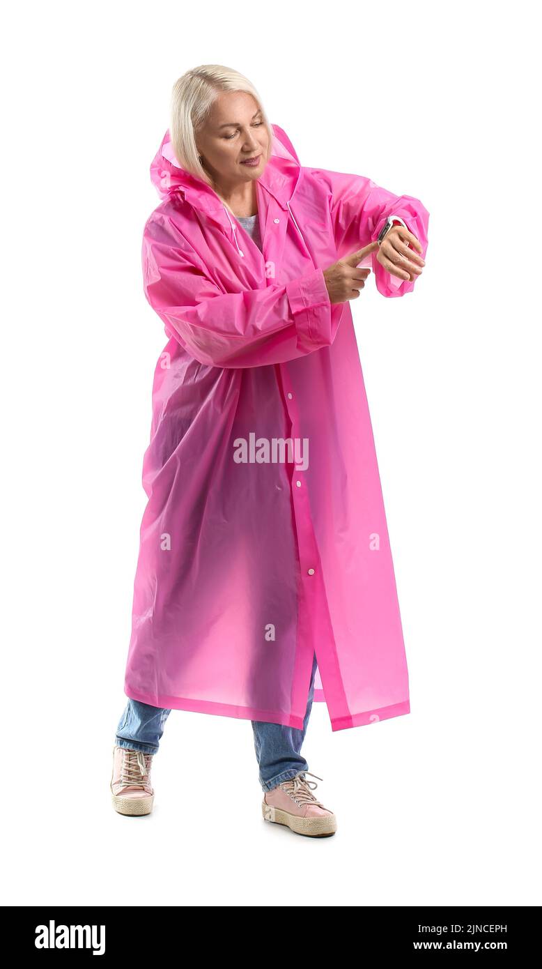 Mature woman in raincoat using smartwatch for navigation on white ...
