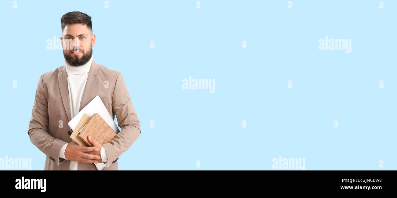 Male teacher of computer sciences on light blue background with space ...