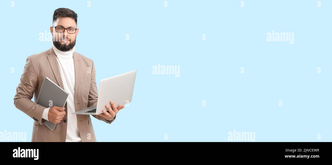 Male teacher of computer sciences on light blue background with space ...
