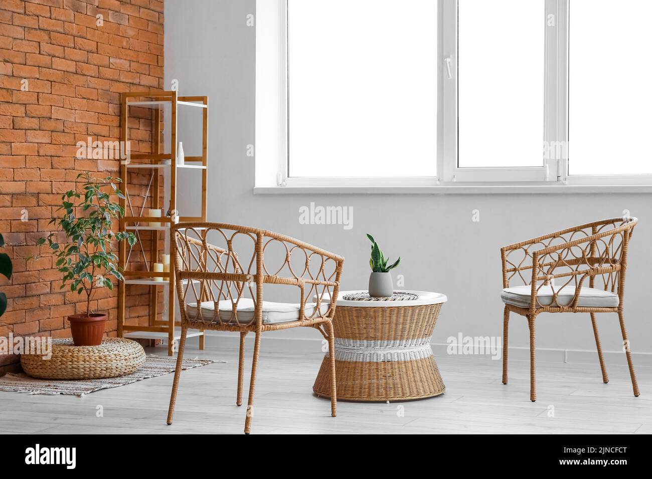 Interior of cozy living room with rattan table, armchairs and shelving ...