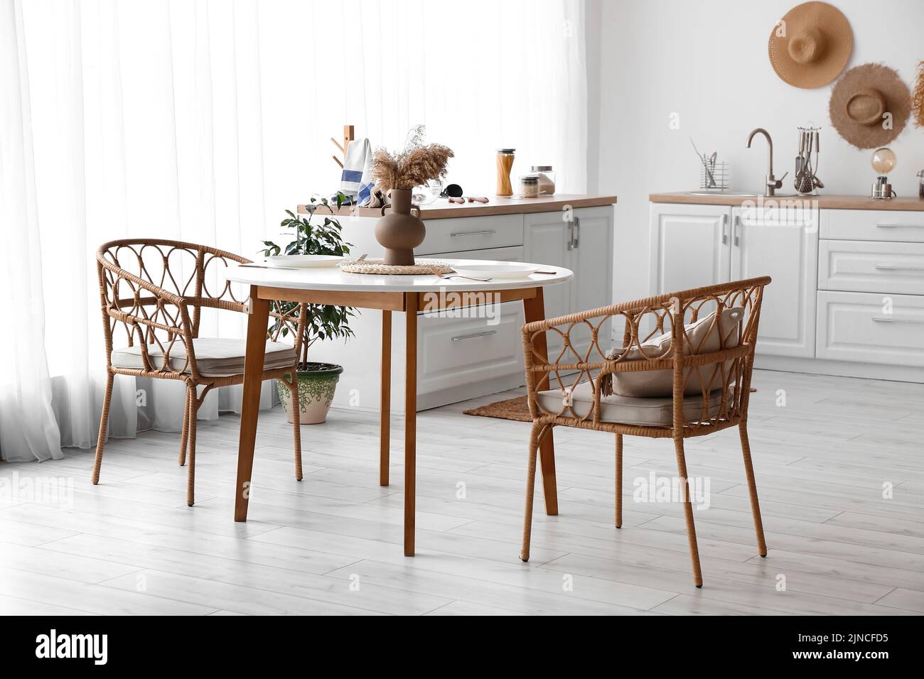 Interior of cozy kitchen with dining table and rattan armchairs Stock ...